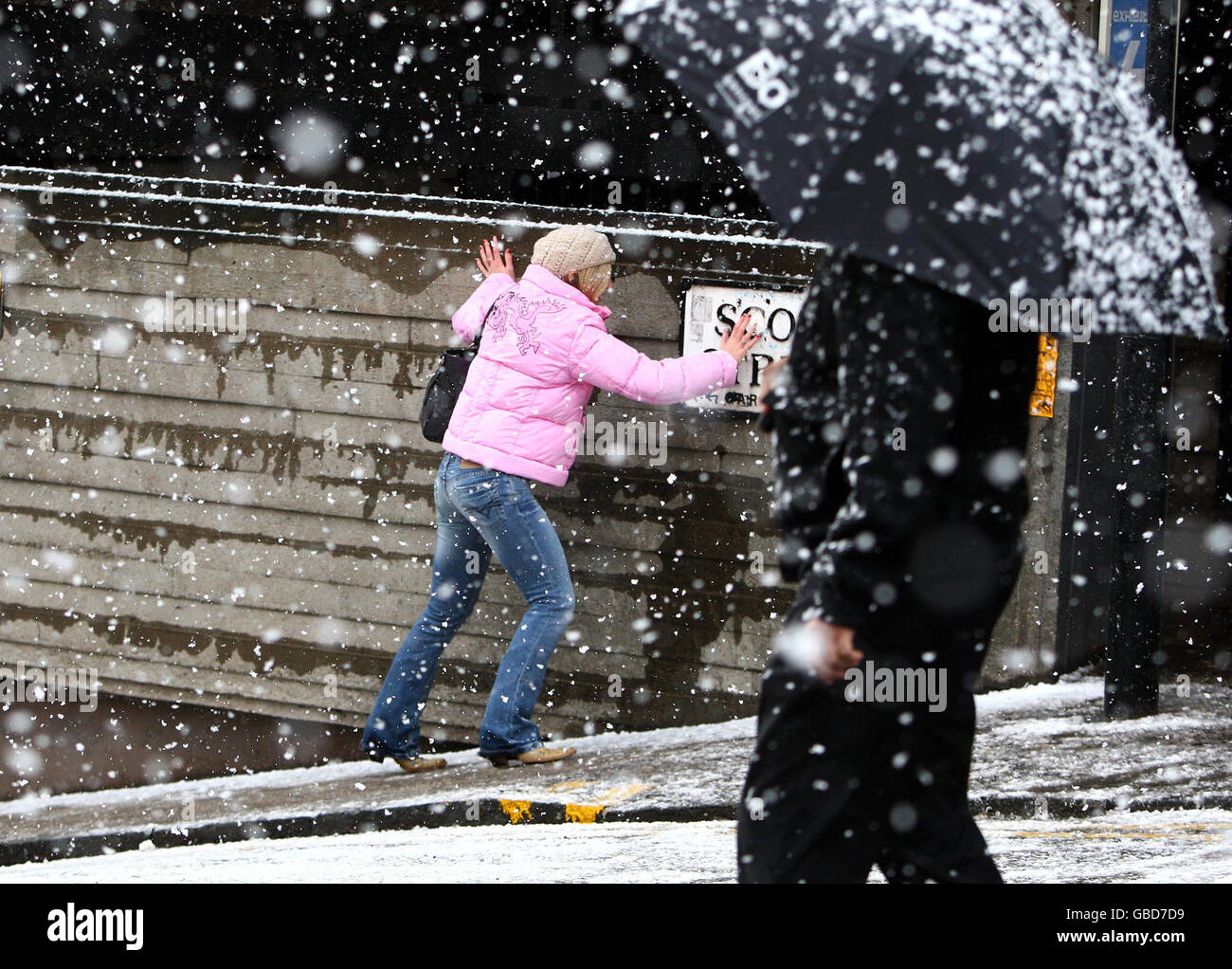 A woman struggles up a hill in a snow blizzard in Glasgow today Stock ...