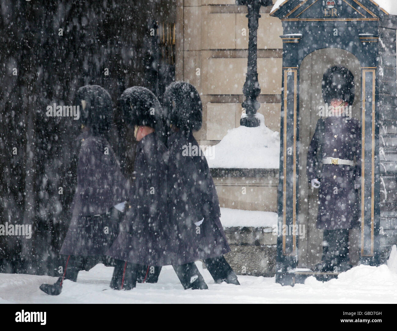 Soldiers on guard duty outside Buckingham Palace march through snow ...