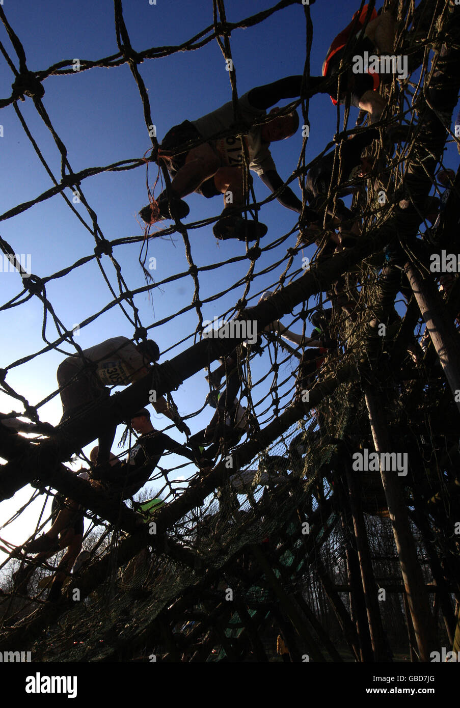 Competitors climb up and over the obstacle known as "The Tiger Stock ...