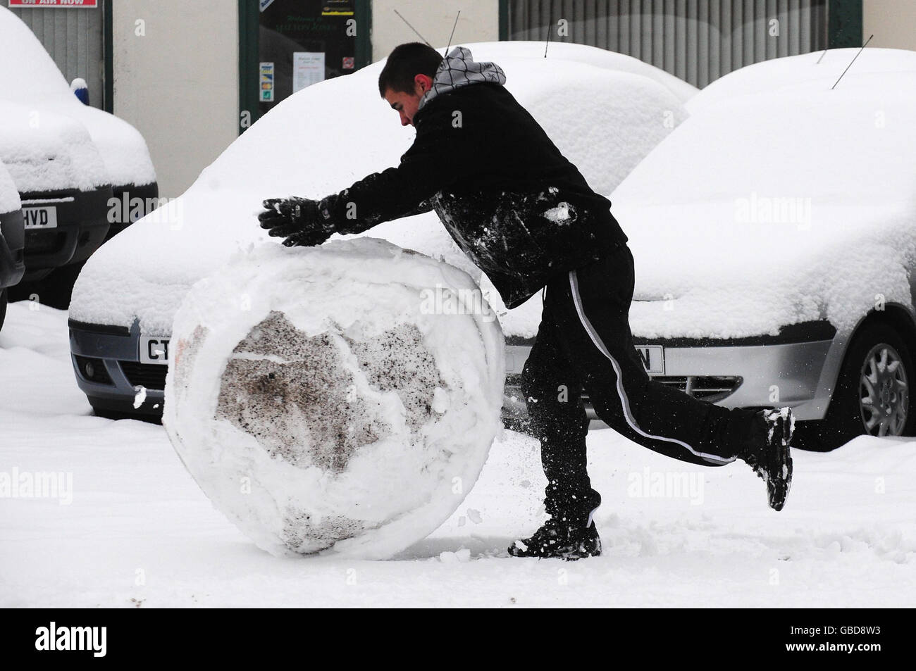 A teenager rolls a snowball in Ashby De La Zouch, Leicestershire Stock ...
