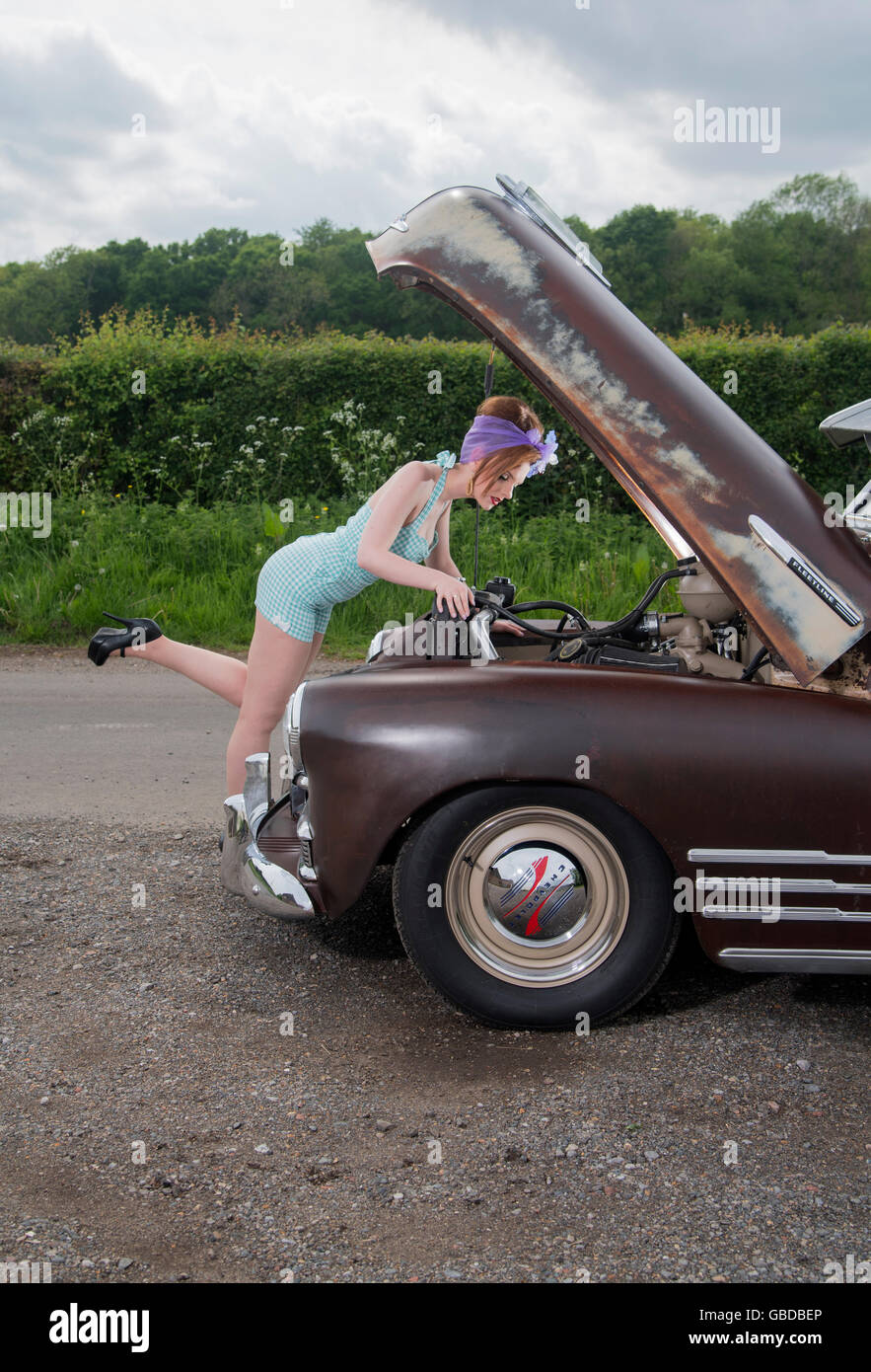 Woman stranded by a broken down old car, stuck at the road side with ...
