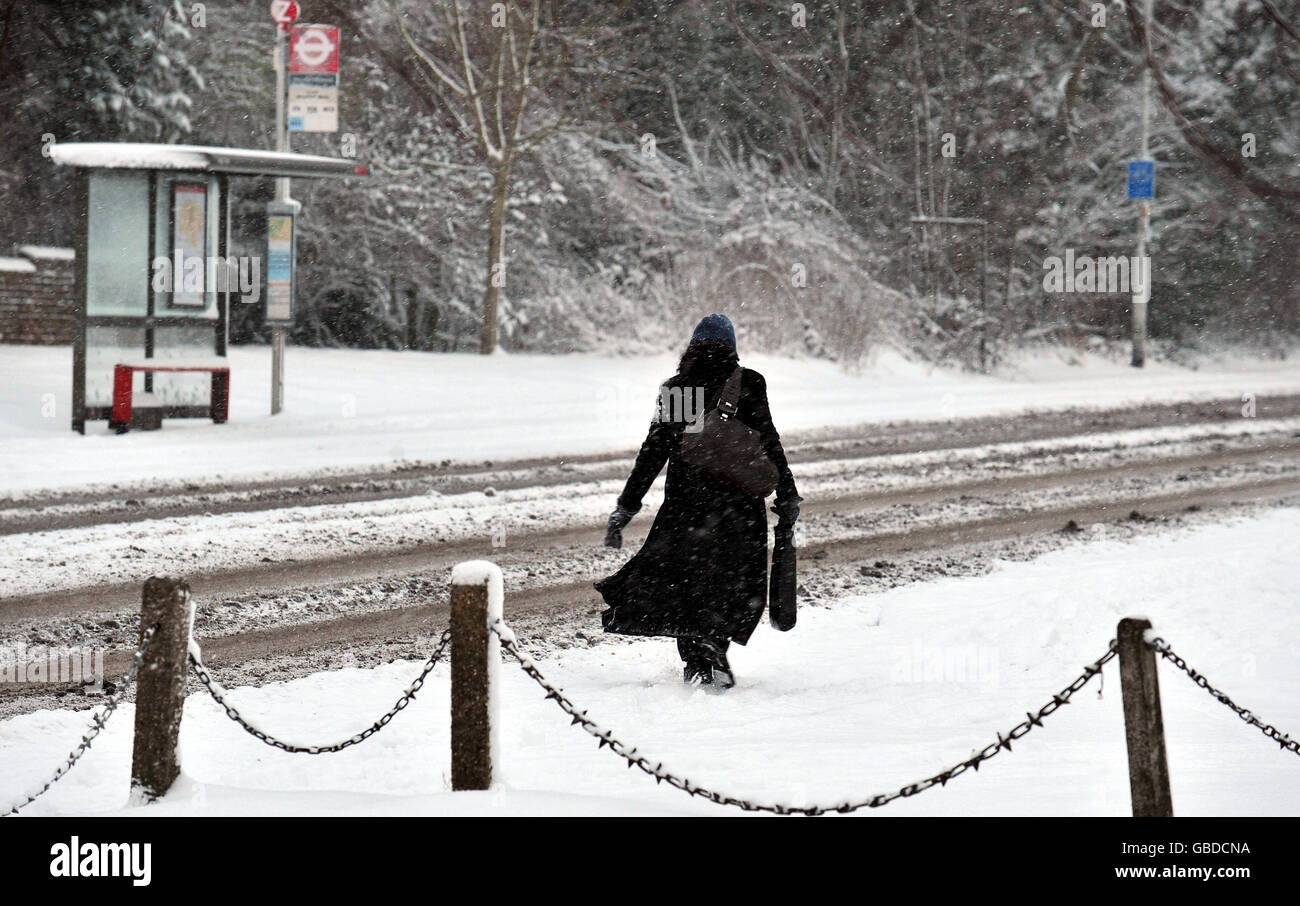 A commuter walks to work through the snow in Woodford Green, Essex, as ...