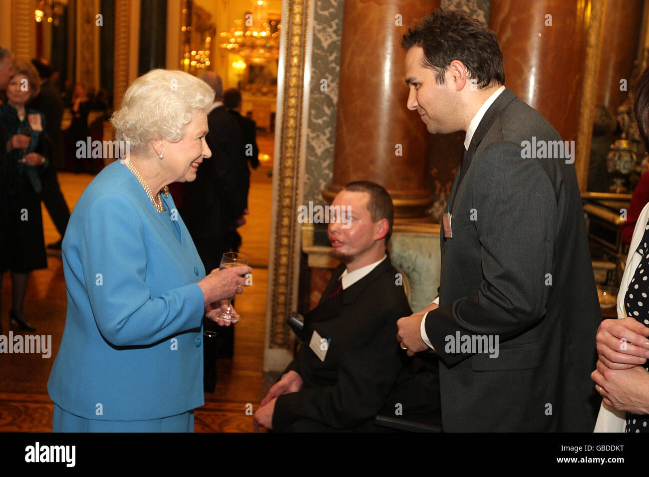 Britain's Queen Elizabeth II talks to Marcus Tripp (centre) from ...