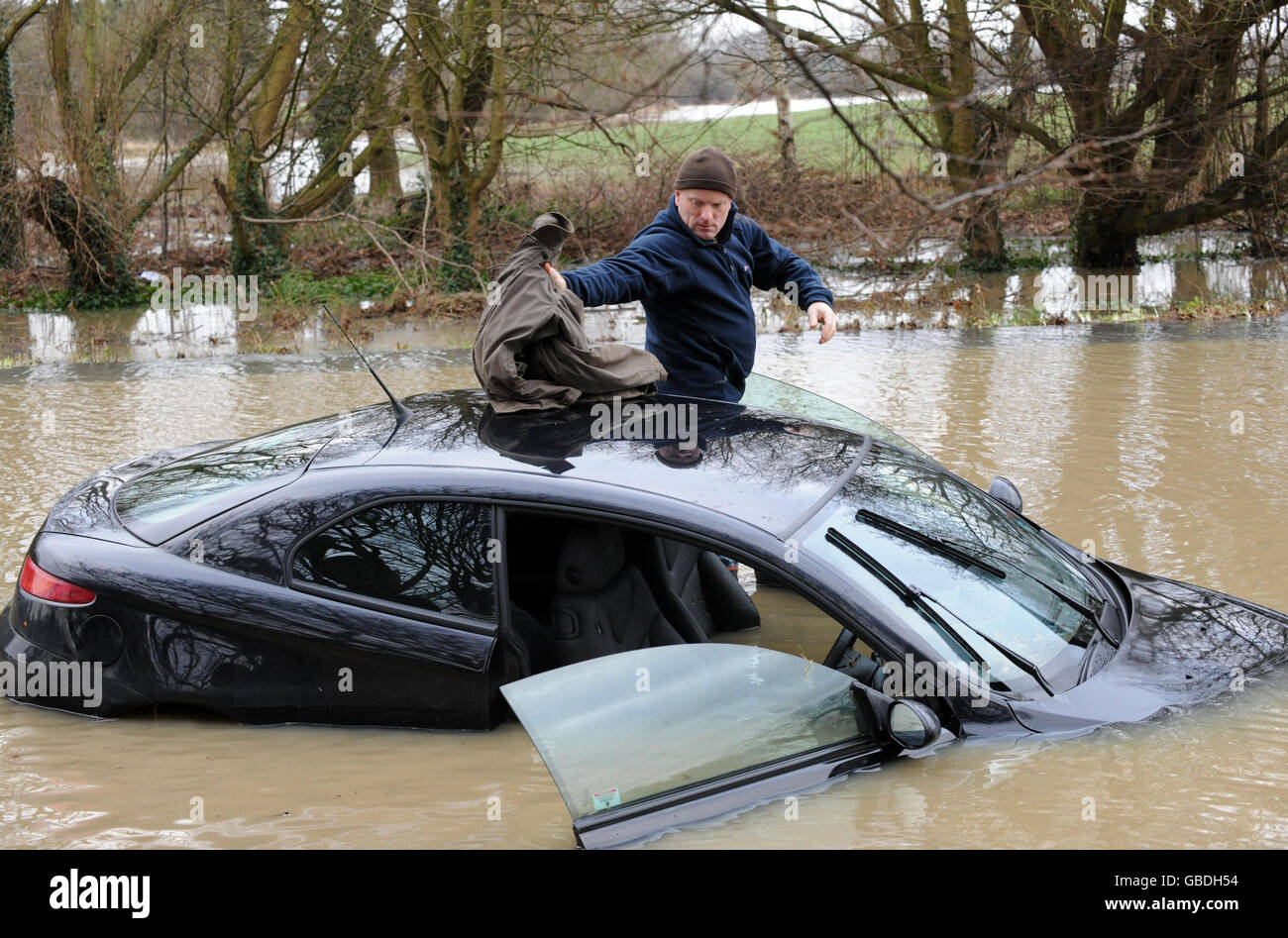 A driver retrieves items from a vehicle stuck in a ditch, which was ...