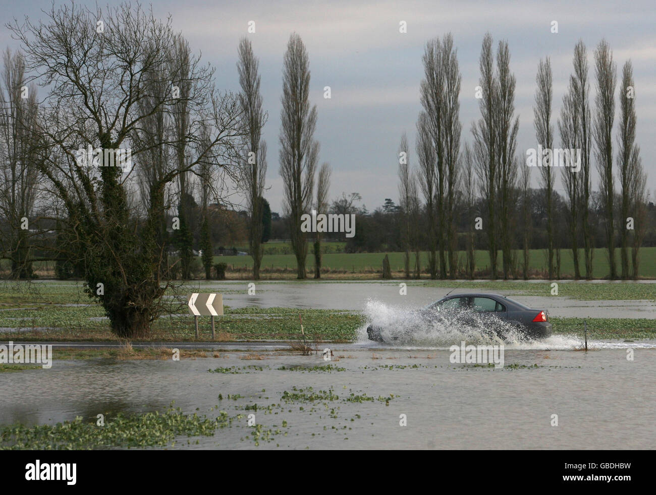 A car struggles along flooded roads as the River Can bursts its banks ...