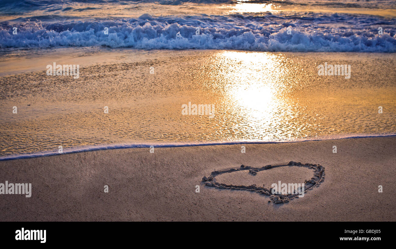 a heart waiting for you on the beach by the sea lit by the sunset Stock ...
