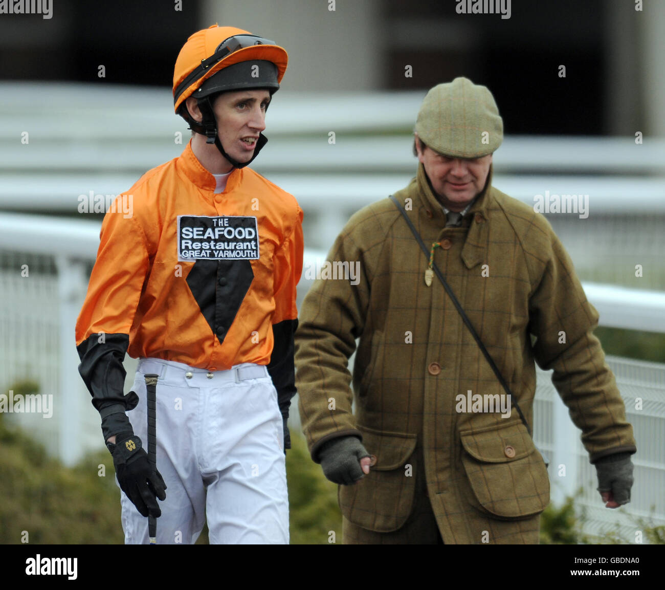 Jockey George Baker speaks with trainer Chris Wall before riding Premio ...