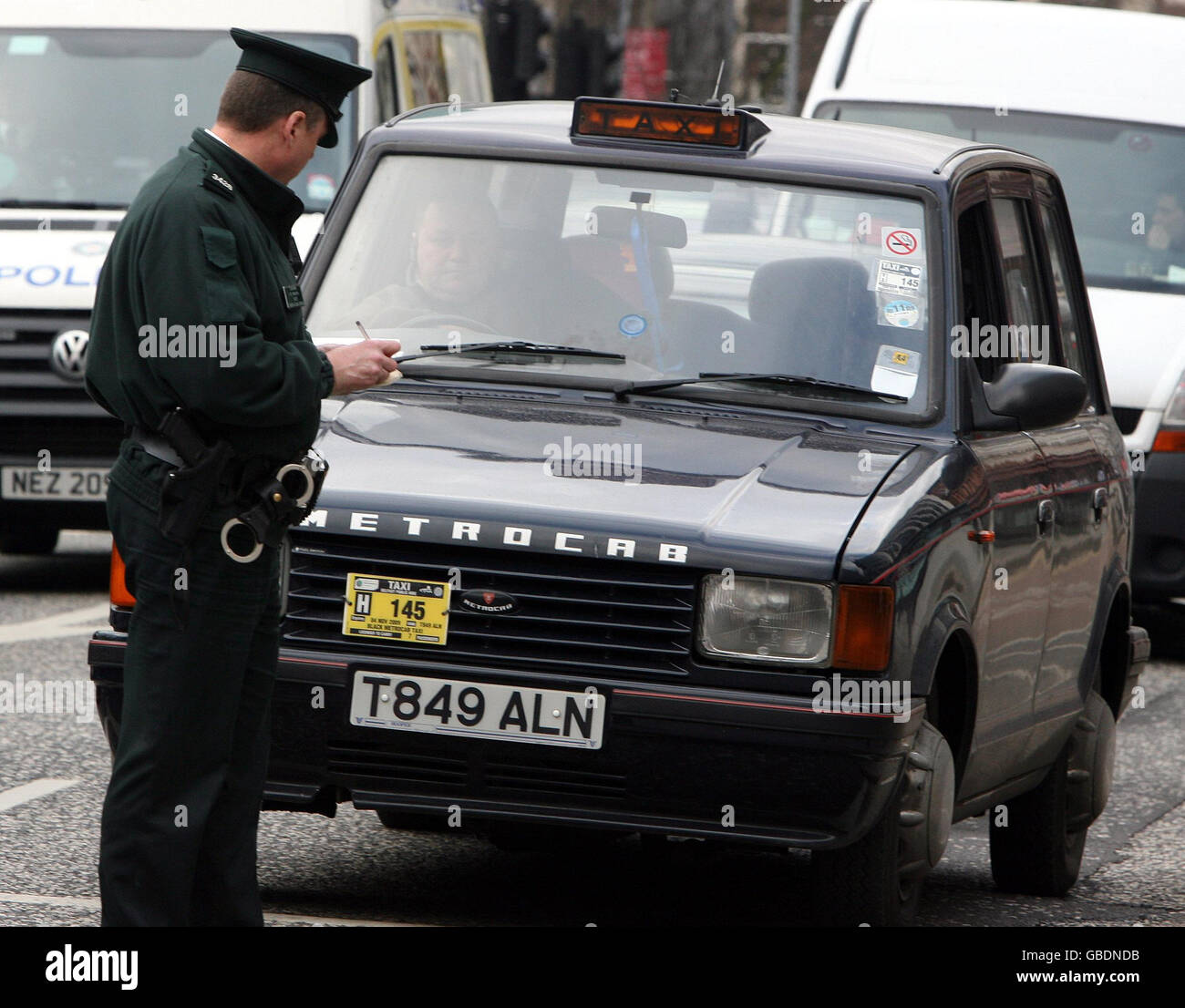 Police note down the registration number of a taxi cab whose driver is ...