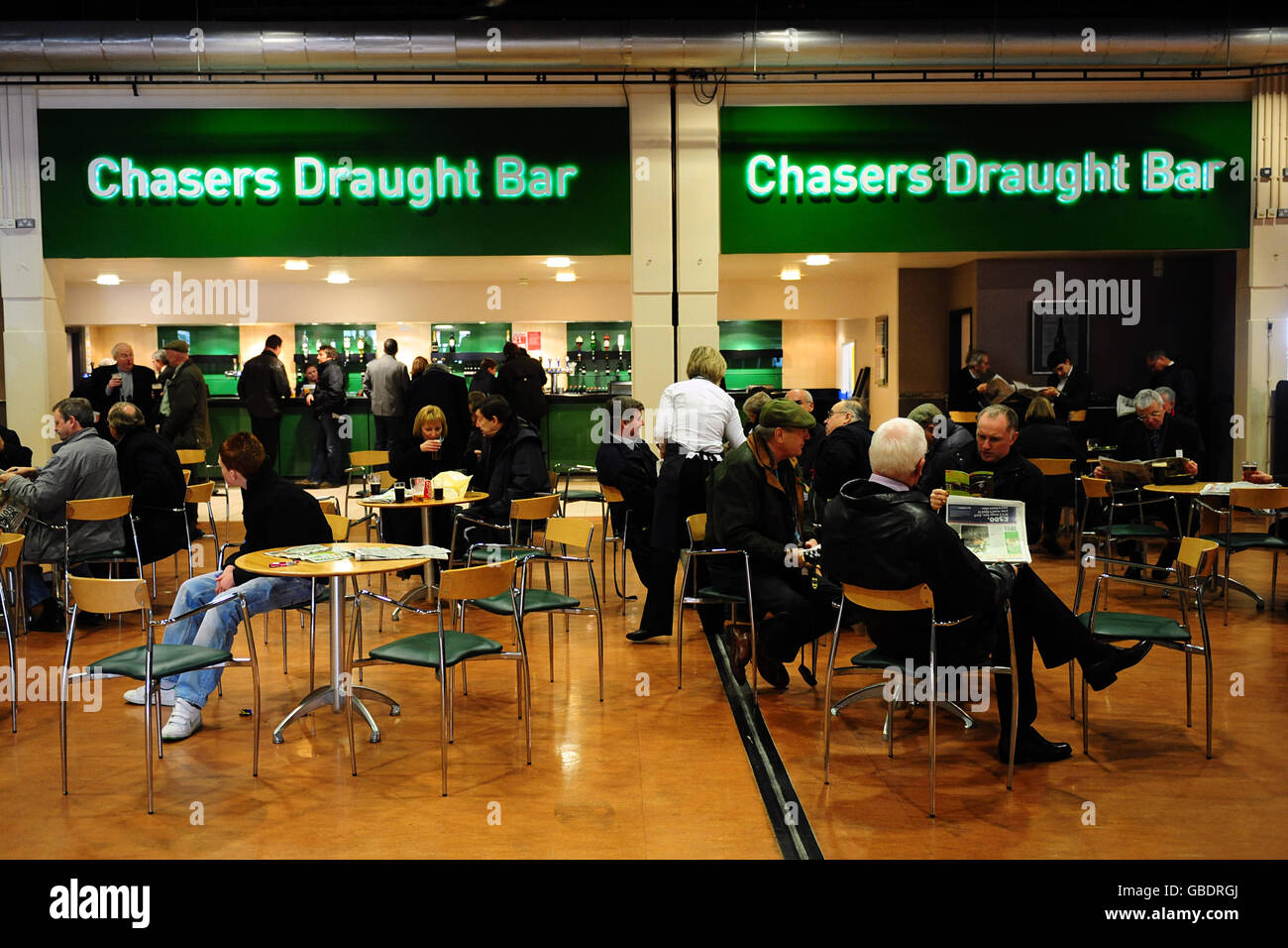 Racegoers enjoy a drink at the Chasers Draught Bar at Sandown Park ...