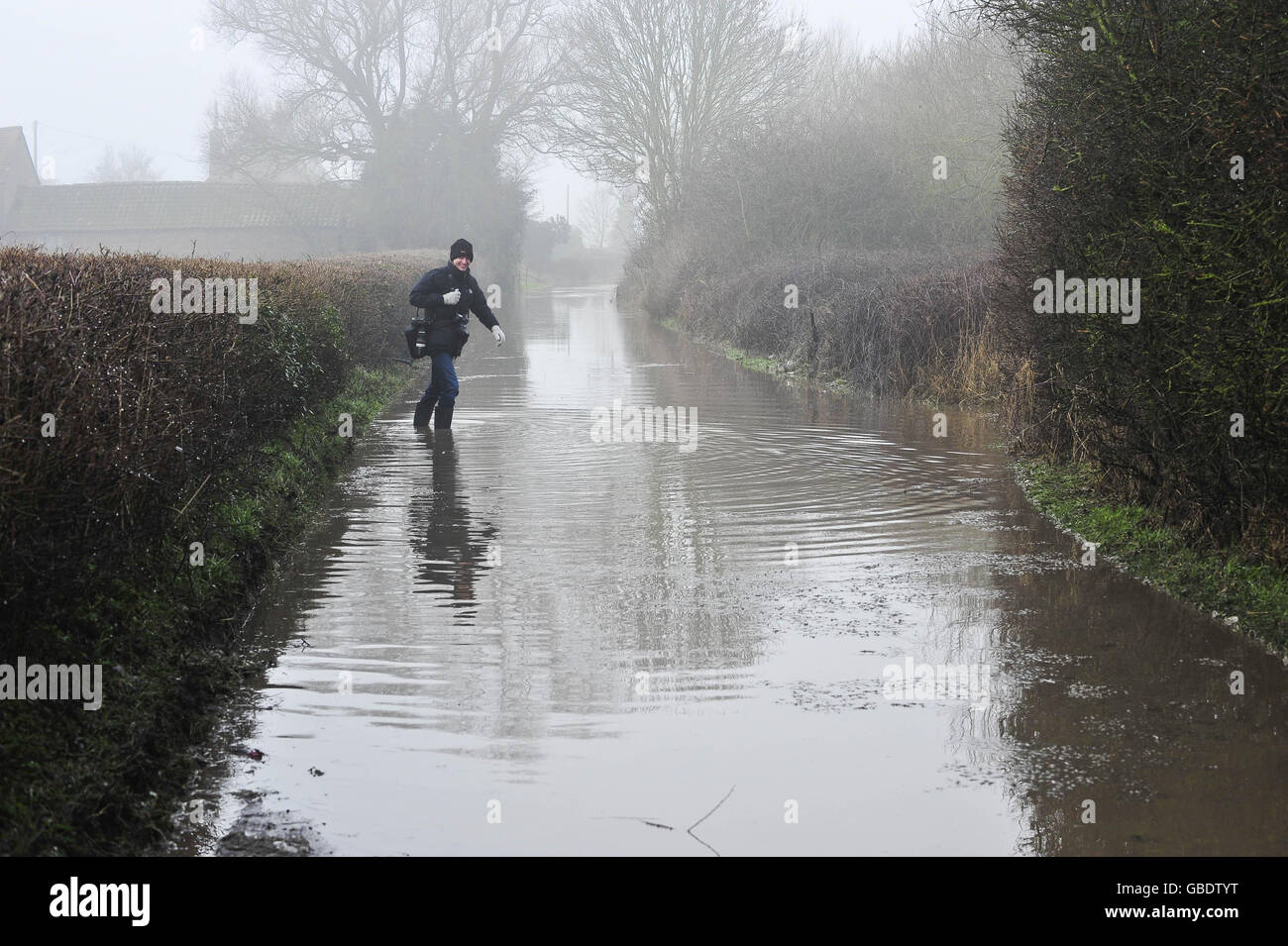 A photographer braves the flood water that has spilled from the river ...