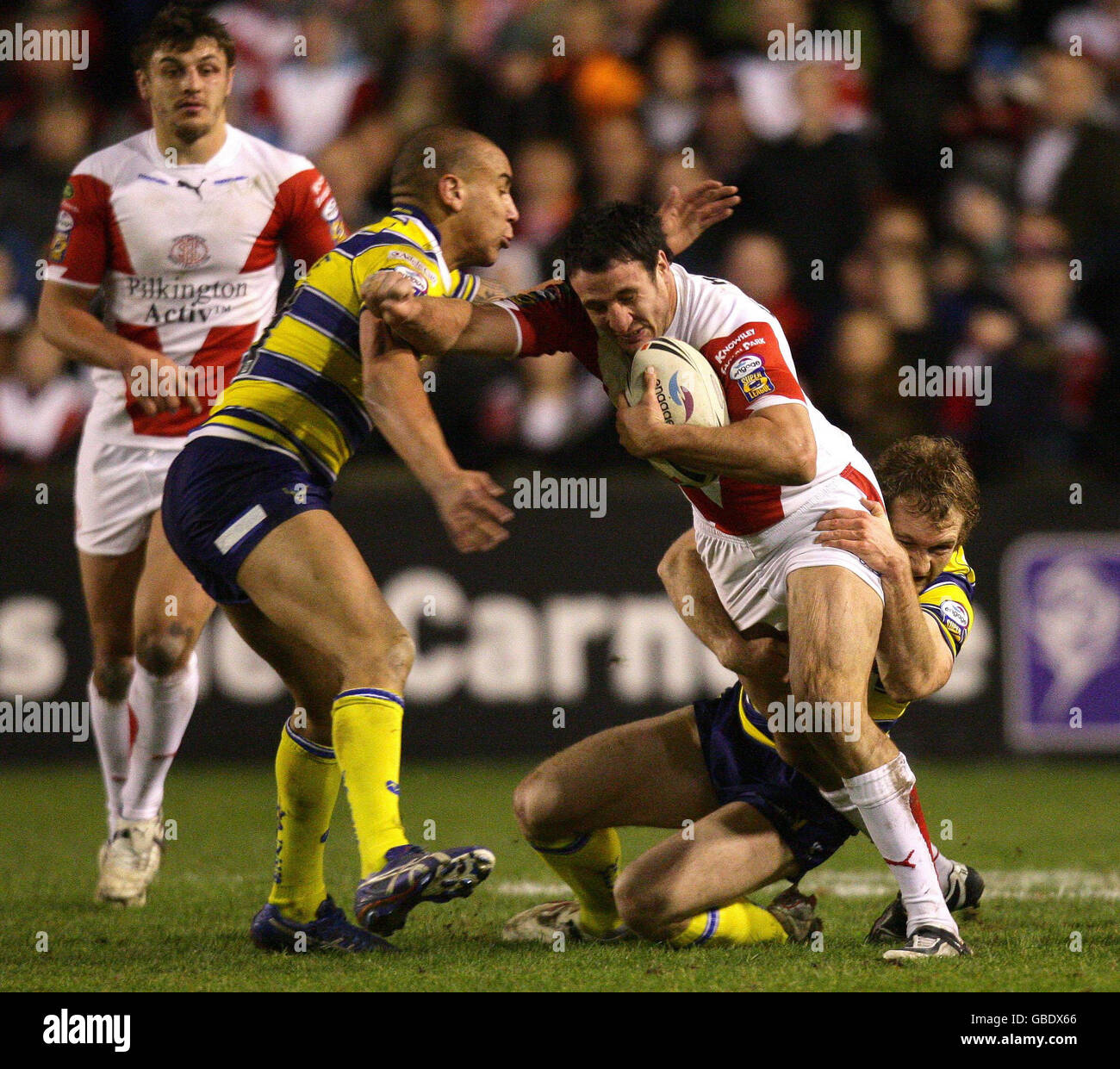 St Helens' Ade Gardner is tackled by Matty Blythe (left) and Michael ...