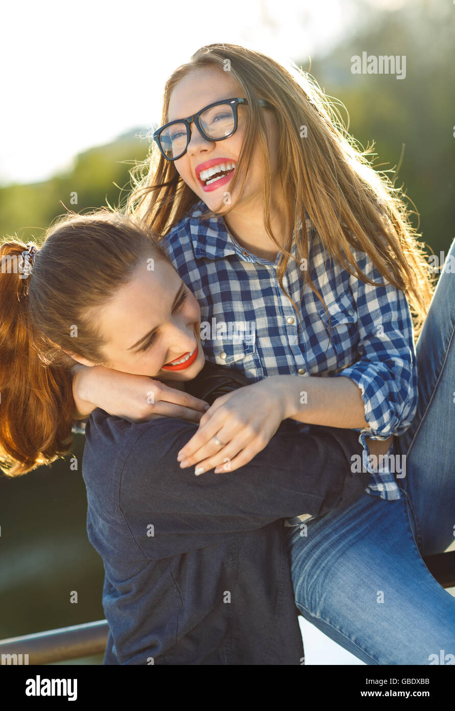 Two playful young women having fun outdoors at sunset light Stock Photo - Alamy