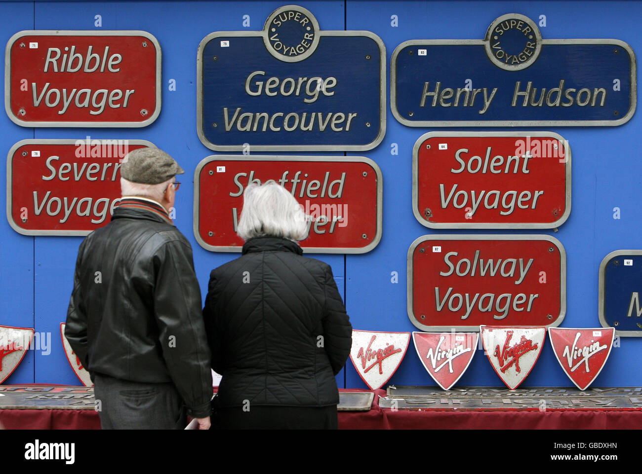 People look at a display of train nameplates and logos at a charity ...