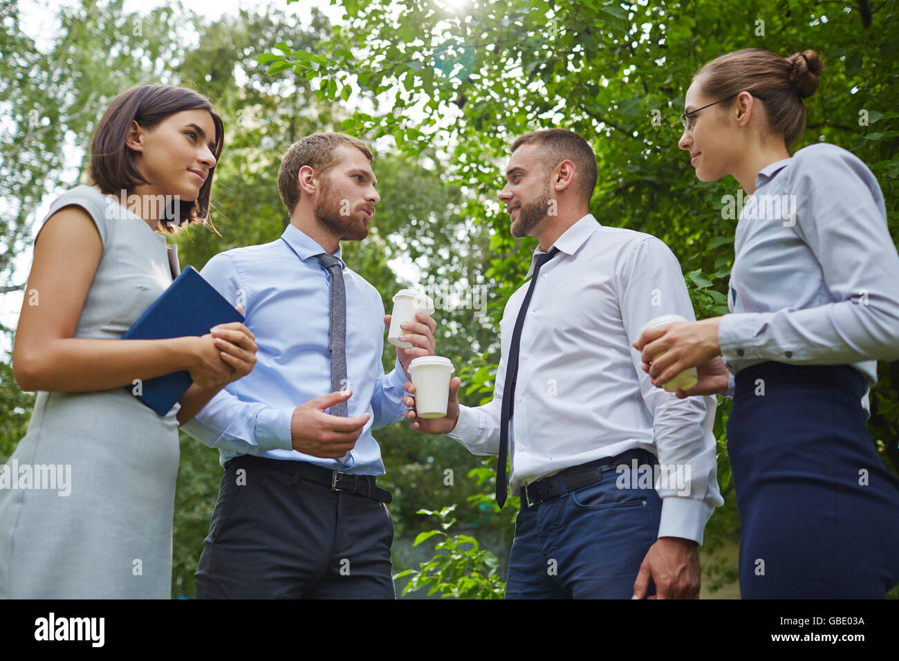Successful employees having discussion in park Stock Photo - Alamy