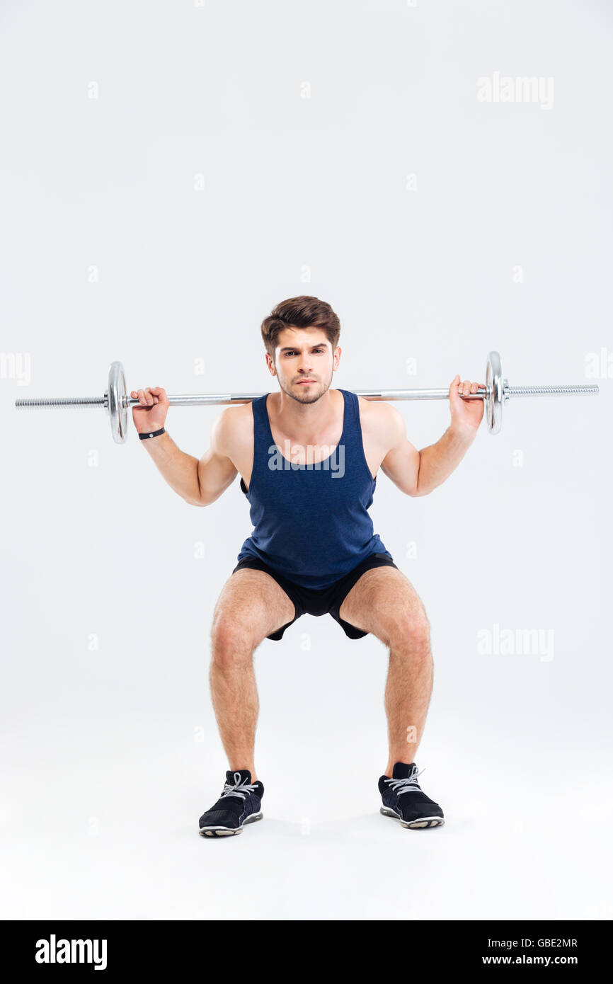 Muscular fitness man doing heavy exercise using barbell isolated on a ...