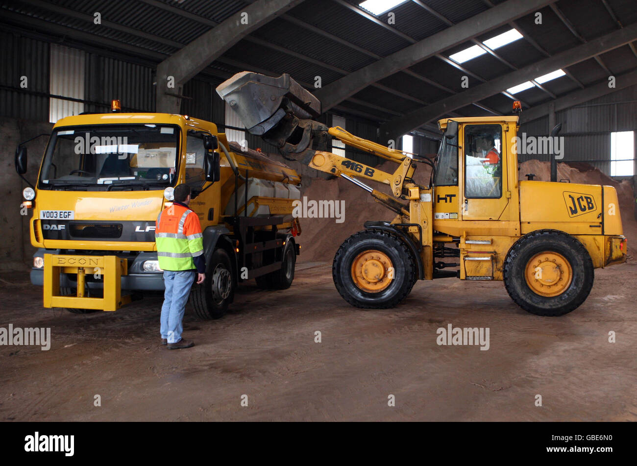 A JCB loads salt grit onto a gritting lorry at Whittlesford Depot in ...