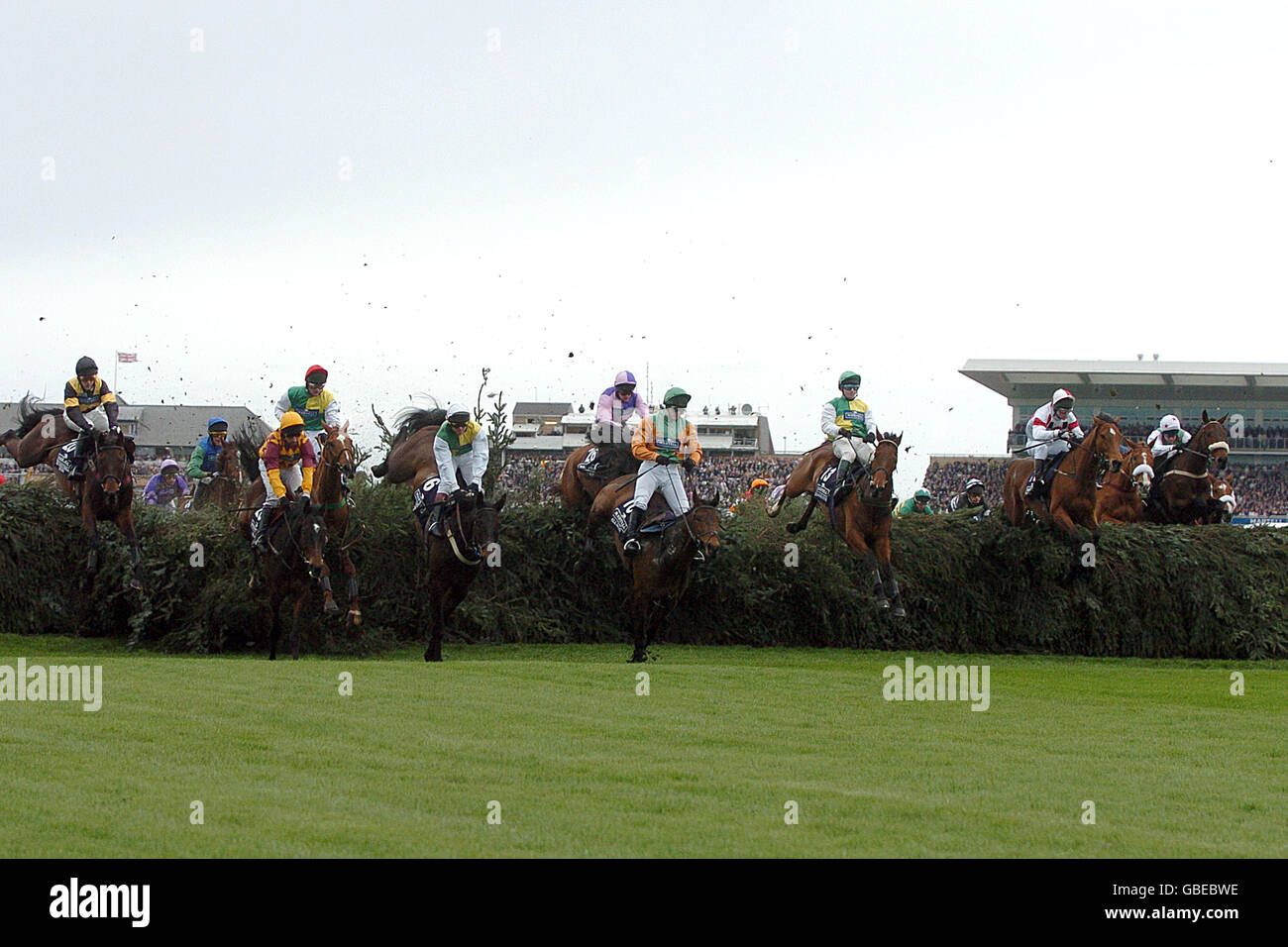 The first riders of the field jump the first fence of The Grand ...