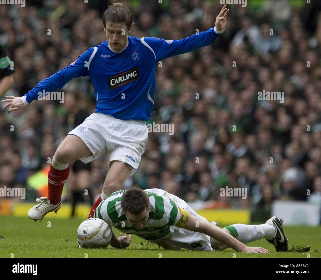 Rangers' Steven Davis beats Celtic's Stephen McManus (floor) during the ...