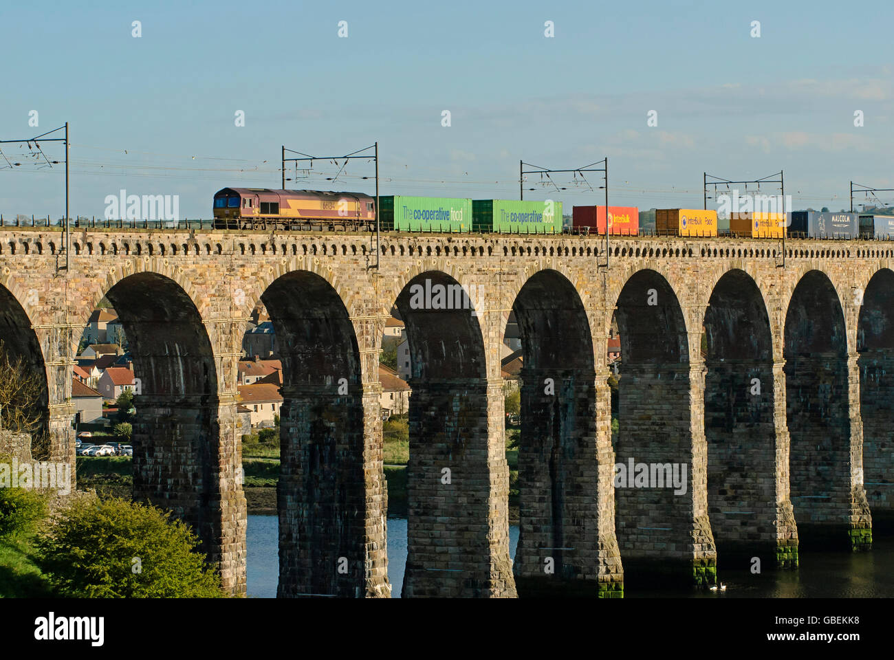 Freight goods train travelling over the railway viaduct built by Robert ...