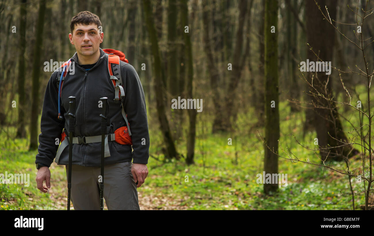 Hiker wearing hiking backpack and jacket on hike in forest Stock Photo ...