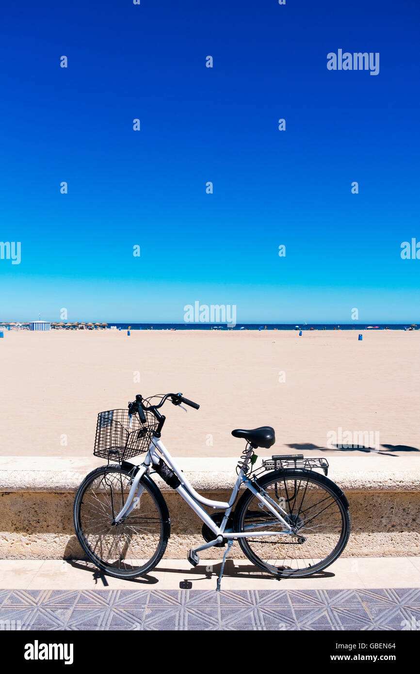 a bicycle parked in the seafront of the popular La Malvarrosa beach, in ...