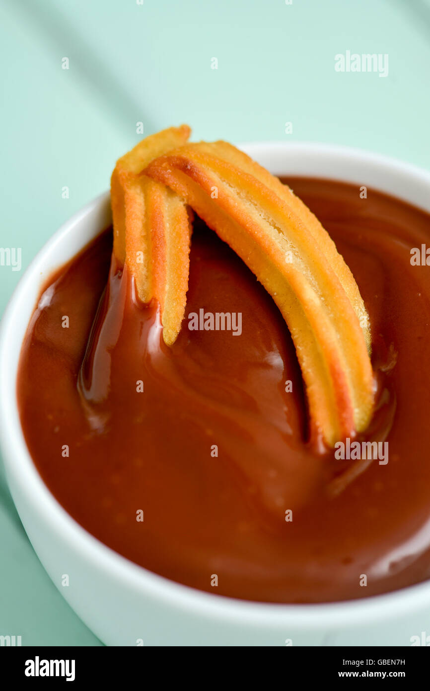closeup of a churro soaked in hot chocolate, a typical Spanish sweet ...