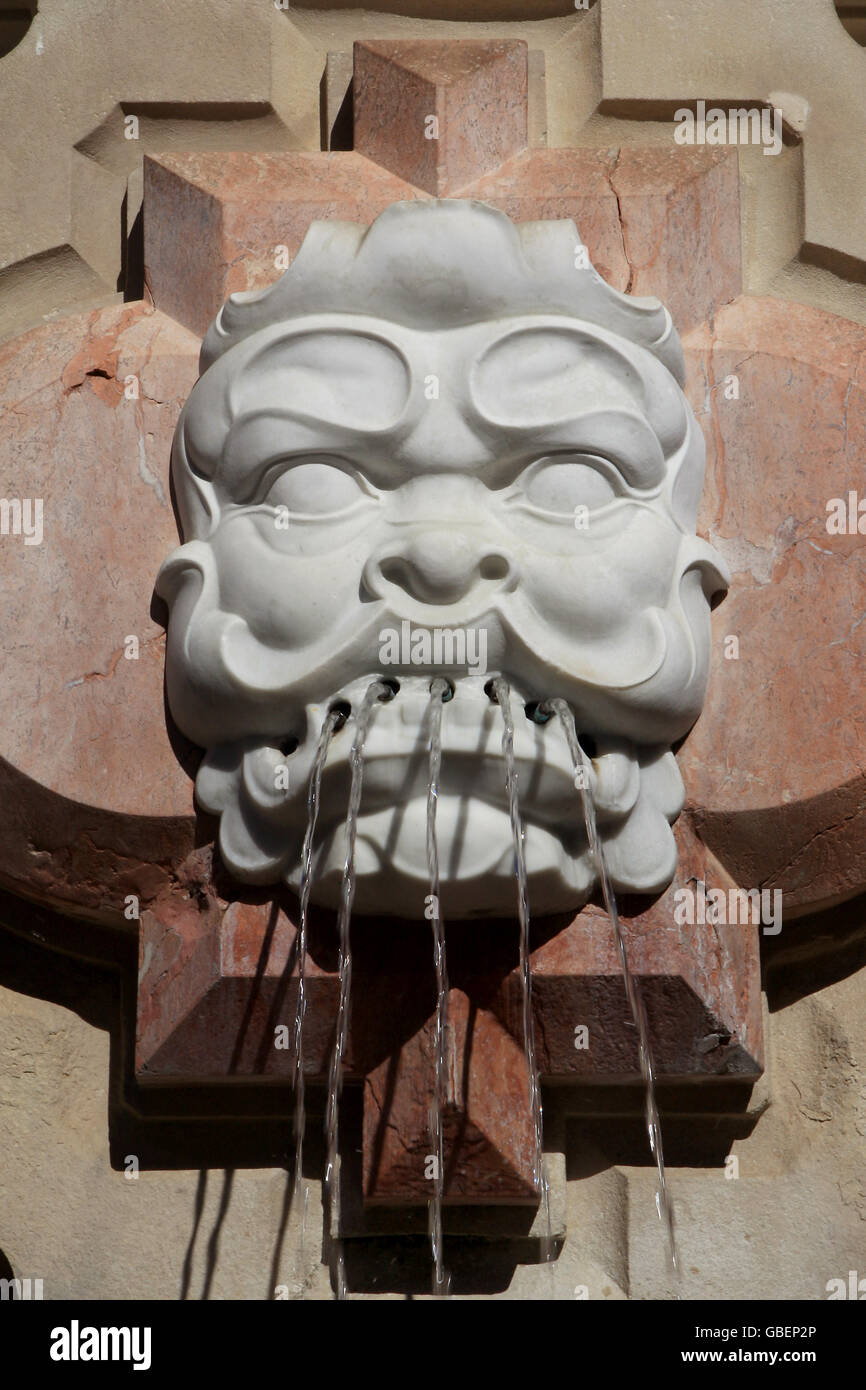 A gargoyle is displayed as a water feature on a building Stock Photo ...