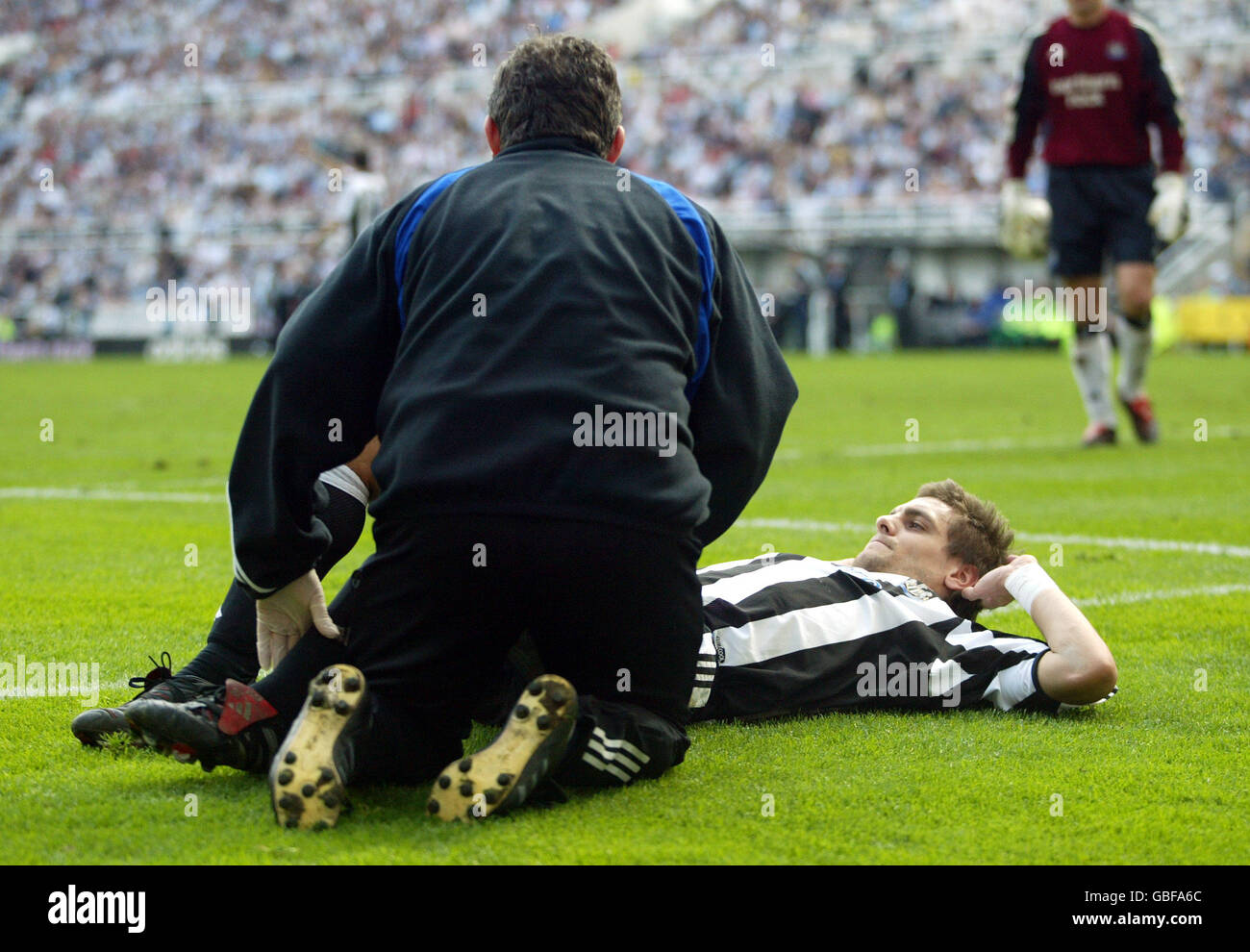 Newcastle United's Jonathan Woodgate lies injured before going off ...