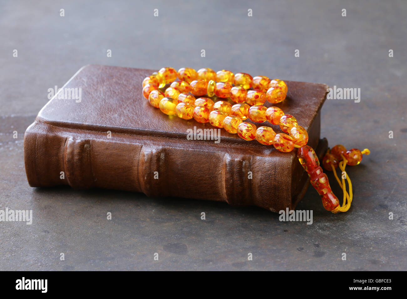 book in a vintage leather bound, and amber beads Stock Photo - Alamy