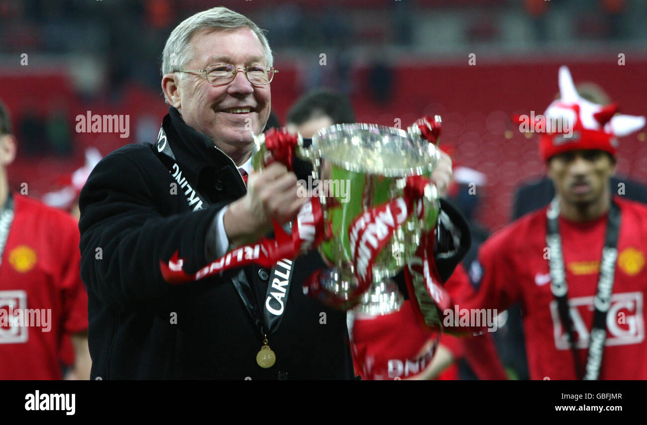 Manchester United manager Sir Alex Ferguson holds the trophy as he ...