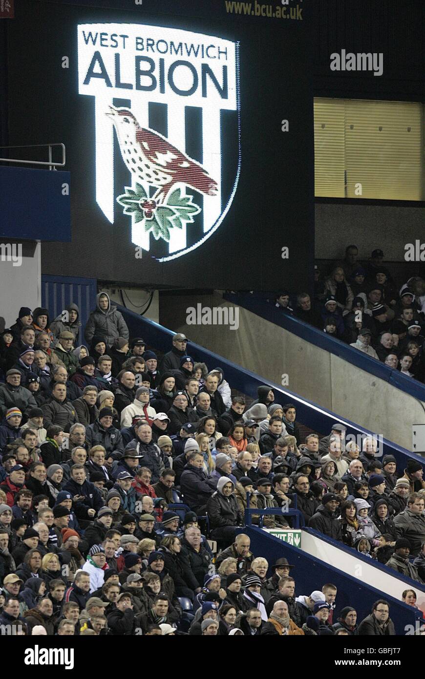 Fans watch the action fromt he stands under a giant TV screen Stock ...