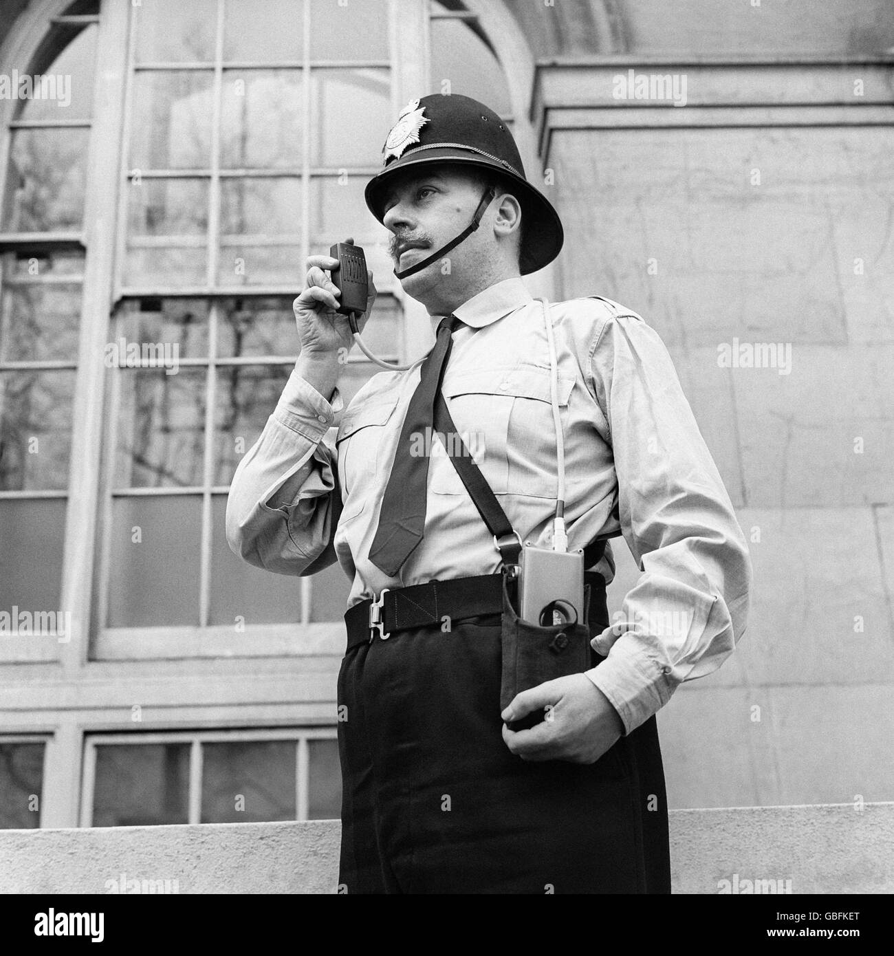 A London policeman has his tunic off to show the walkie-talkie radio ...