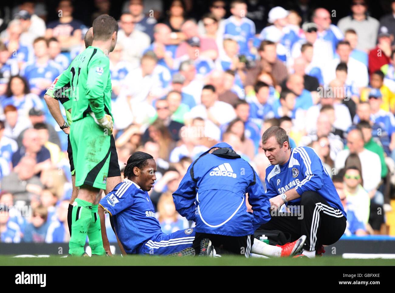 Chelsea's Didier Drogba recieves treatment for an injury on the pitch ...