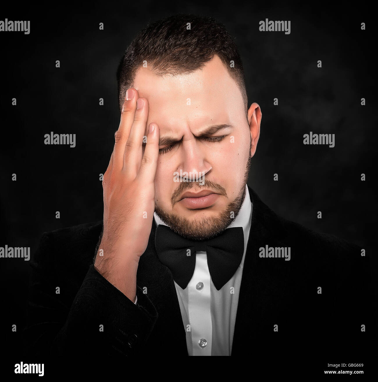 Young man holding his head feeling a headache or intensely thinking ...