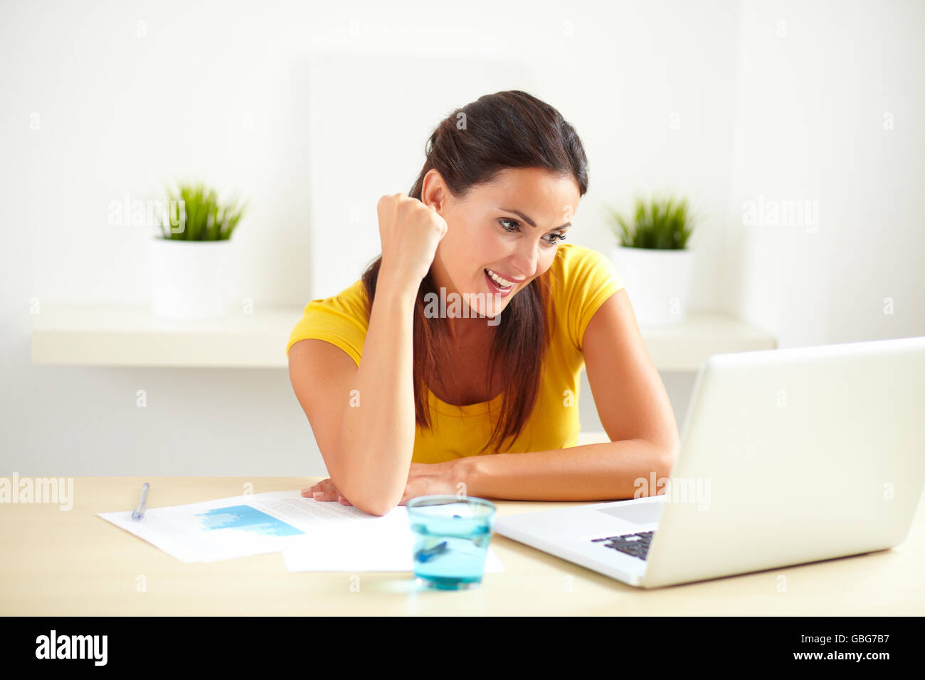 Hispanic female employee doing customer service while celebrating in ...