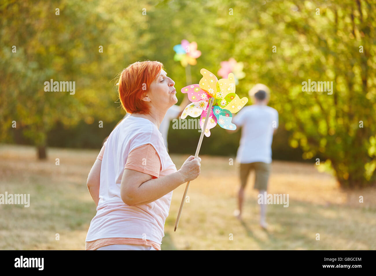 Senior woman playing with a pinwheel in the summer in the park Stock ...