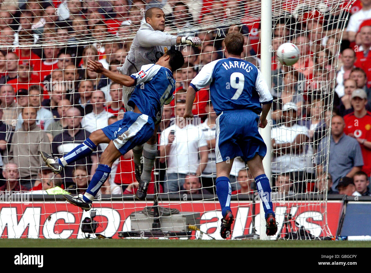 Manchester United goalkeeper Tim Howard (l) punches the ball away as he ...