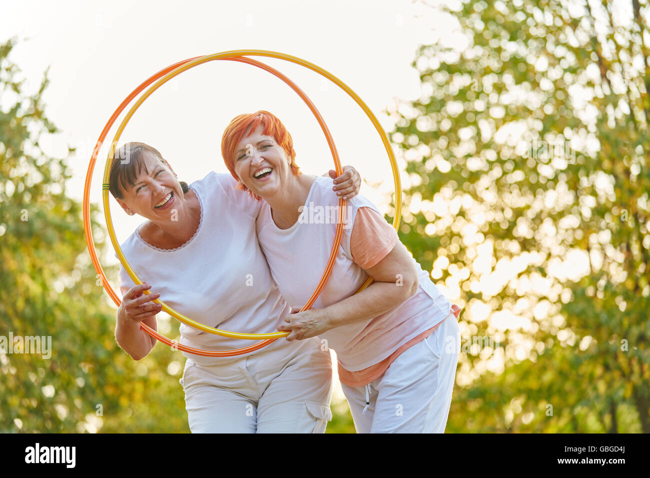 Two active women having fun in the park with hoops in the park Stock ...