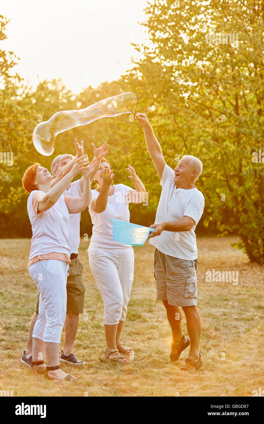 Seniors having fun while playing with soap bubbles in the park Stock ...