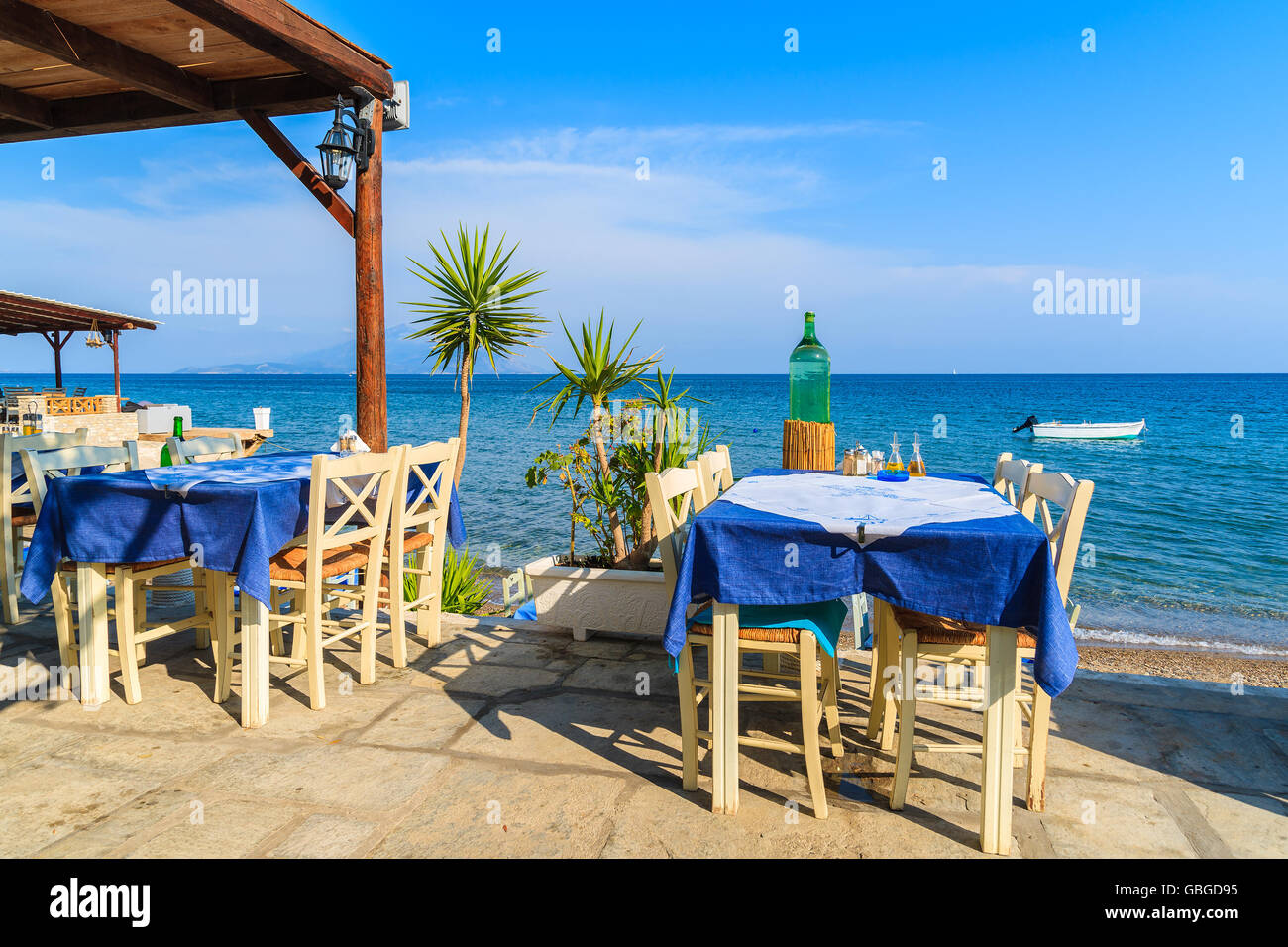 Typical Greek tavern in small fishing village on coast of Samos island ...