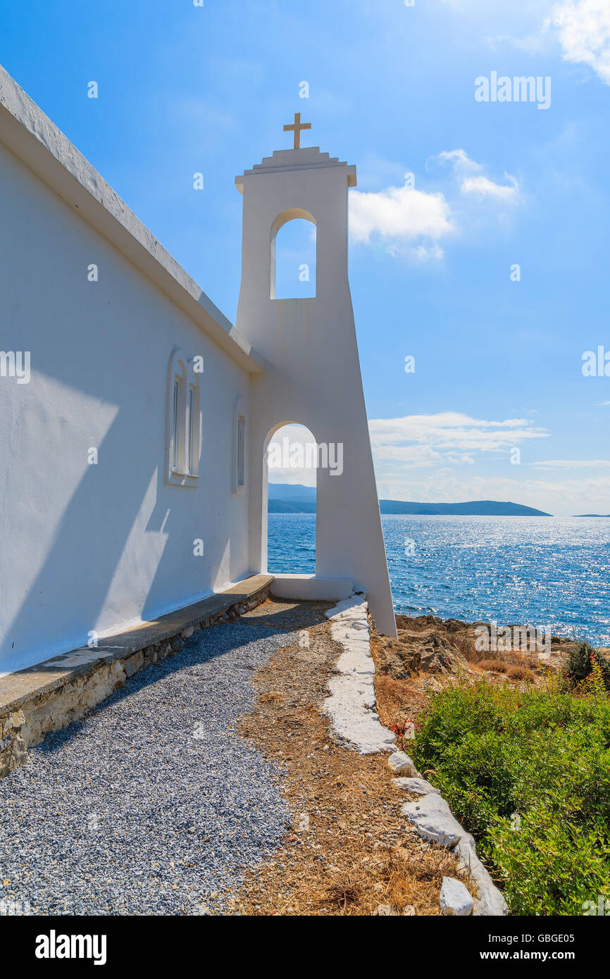 Tower of white Greek church in back light on coast of Samos island ...