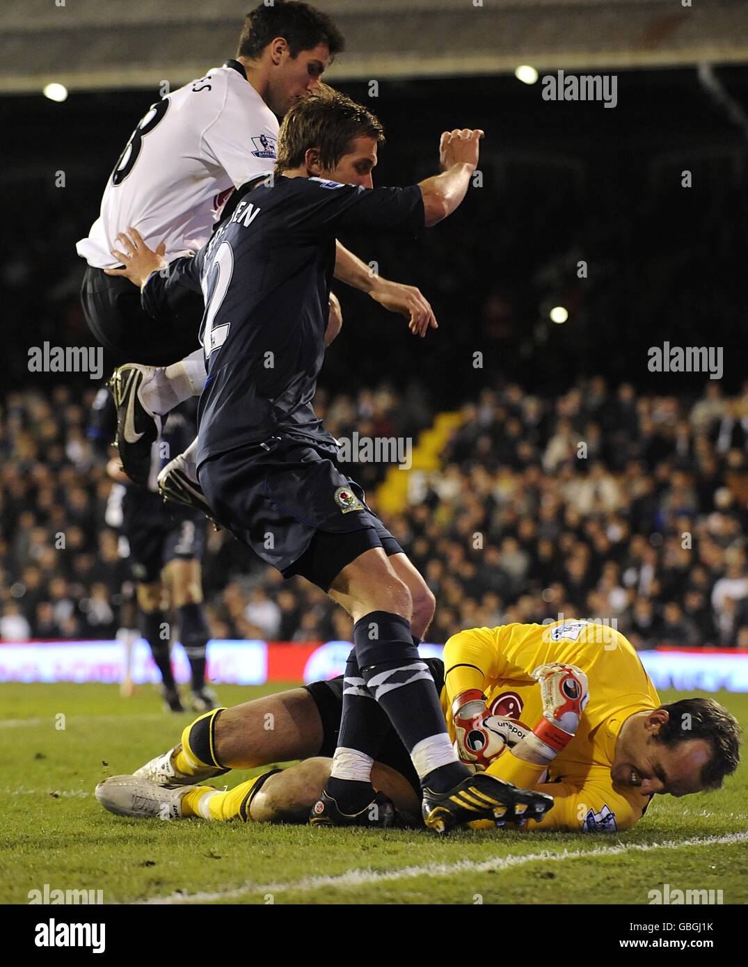 Fulham goalkeeper Mark Schwarzer (floor) dives at the feet of Blackburn ...