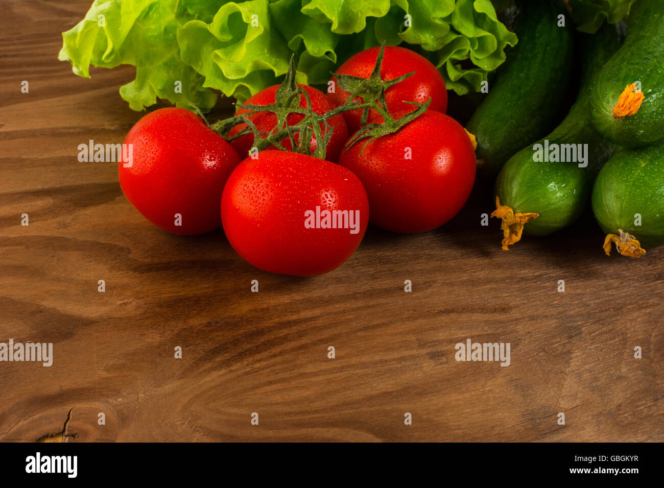 Cherry tomatoes and cucumber on wooden table. Tomato. Cucumber. Ripe ...