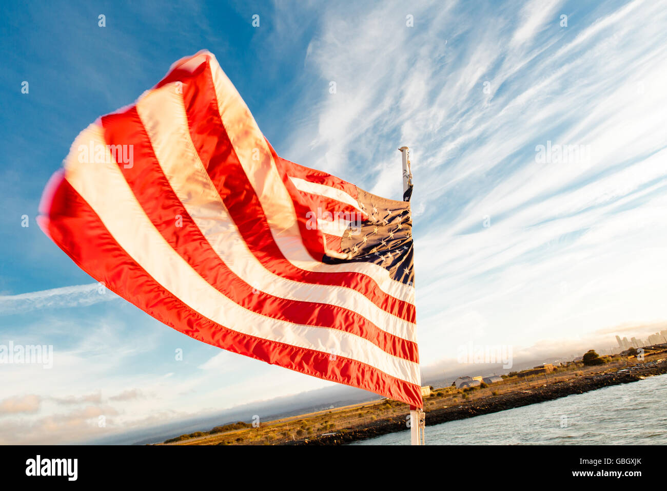 American Flag waves in the wind of back of ship in San Francisco Bay ...