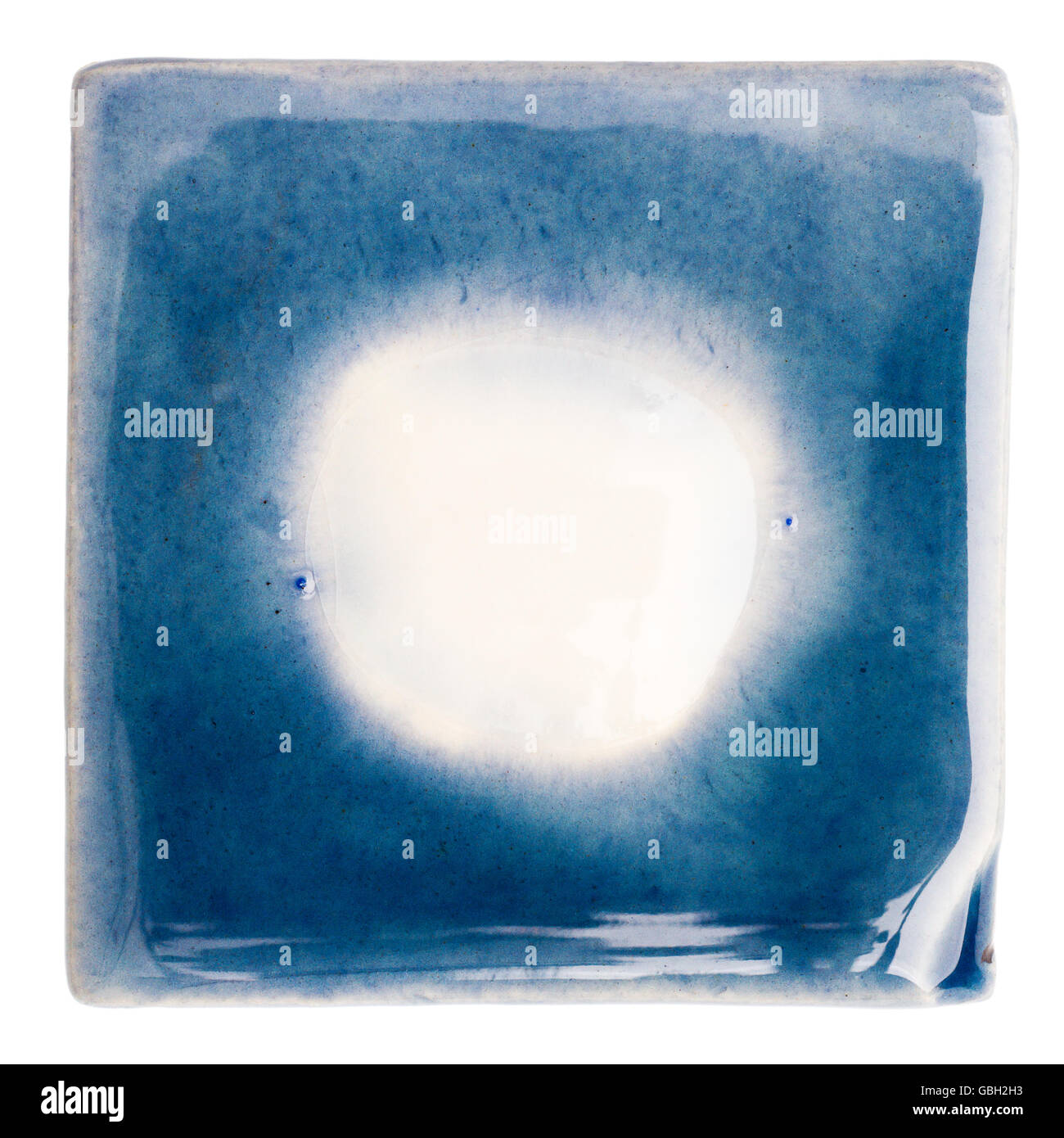 Blue handmade glazed ceramic tile with big dot in middle cutout on ...