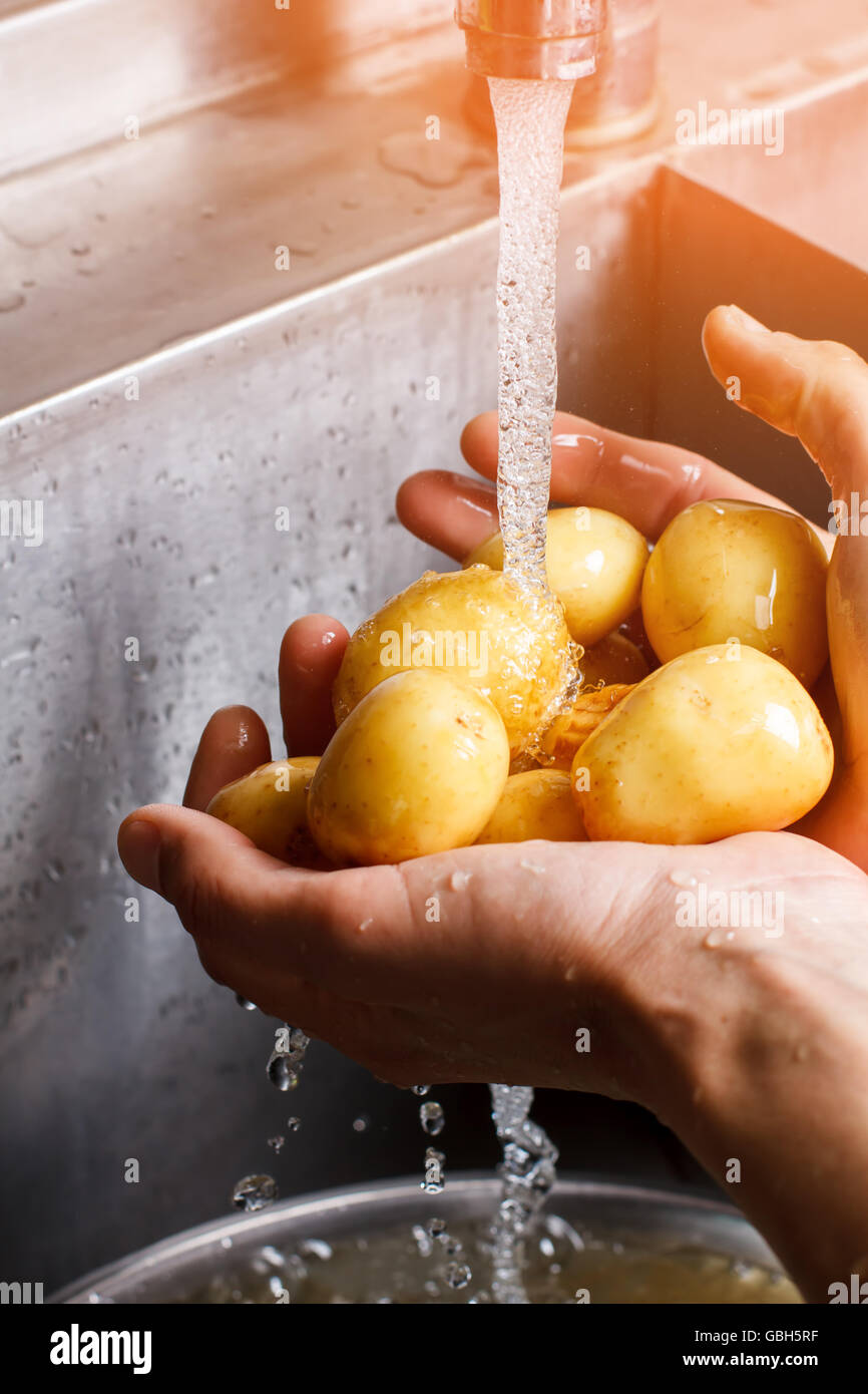 Male hands washing potatoes Stock Photo - Alamy