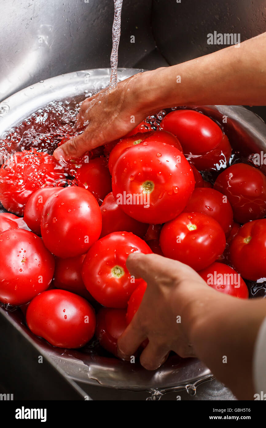 Hands wash tomatoes in basin Stock Photo - Alamy