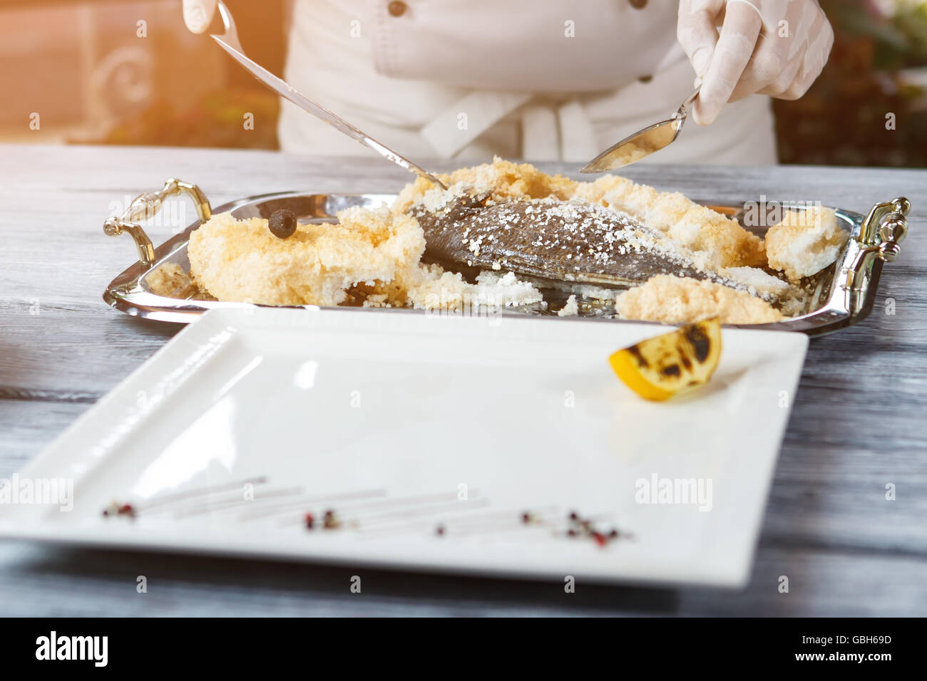 Hands with spatula touch fish Stock Photo - Alamy