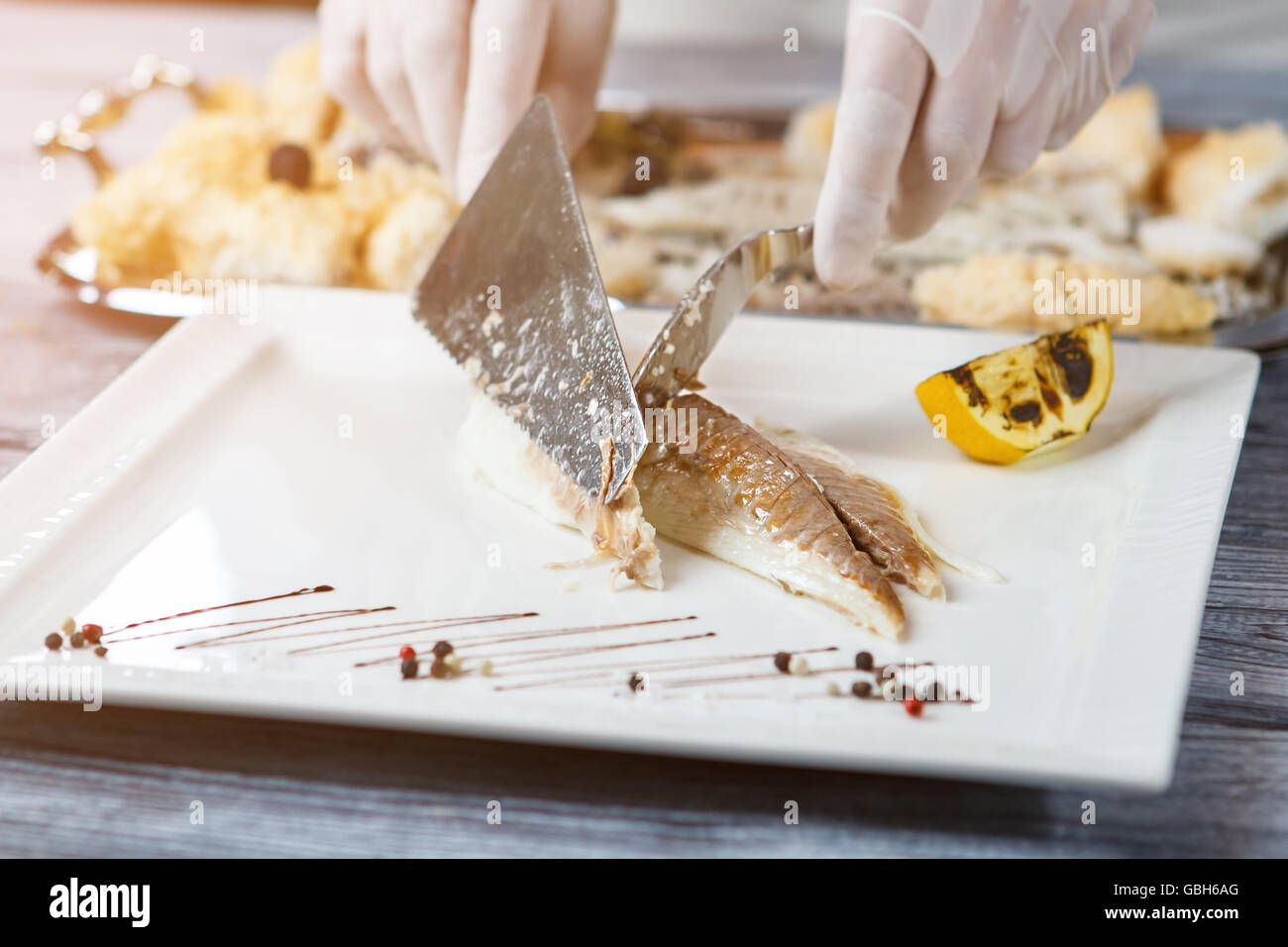 Hands with spatula touching fish Stock Photo - Alamy
