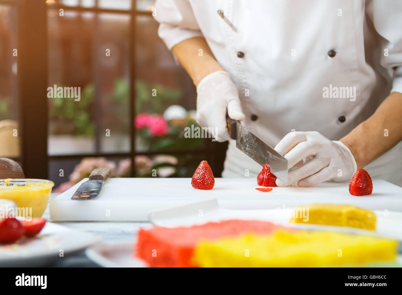 Hand with knife cutting strawberry Stock Photo - Alamy
